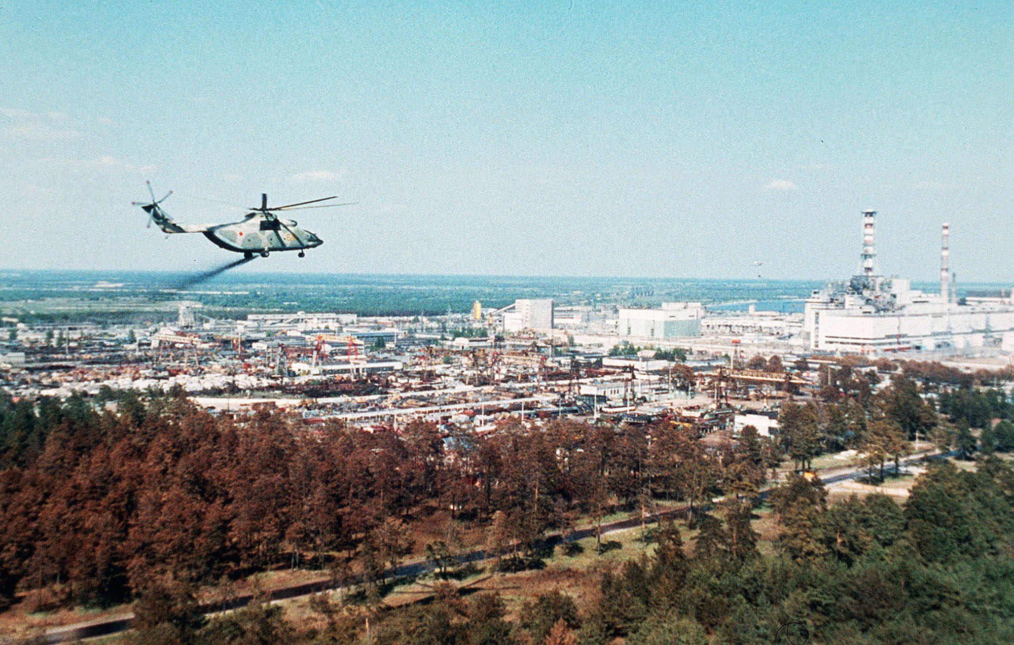 A military helicopter spreads sticky decontamination fluid supposed to ...
