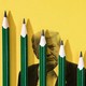 An illustration of pencils lined up in front of a photo of Donald Trump