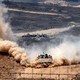 An Israeli army infantry-fighting vehicle (IFV) leaves a cloud of dust as it moves at a position along Israel's southern border with the Gaza Strip on August 5, 2025. Israel's Prime Minister Benjamin Netanyahu on August 5 prepared to unveil an updated Gaza war plan designed to destroy Hamas and secure the release of dozens of hostages, with Israeli media reporting he would order the total occupation of the Palestinian territory.
