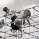 A black-and-white image of children playing on a jungle gym.