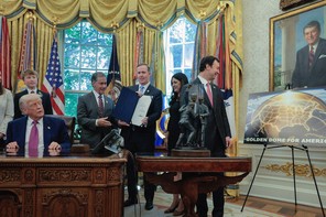 Photograph of Trump and other officials with a sign for the Golden Dome in the White House