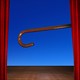 A horizontal cane between two open curtains
