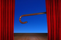 A horizontal cane between two open curtains