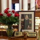 An image of Representative Melissa Hortman's seat in the Minnesota State Capitol building with flowers and a framed photo of her.